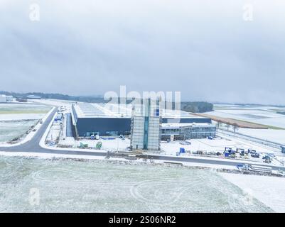 Building with scaffolding and snow-covered factory in the wintry ...