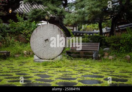 Green moss-covered stone plaza and park bench located in Jeonju, South ...