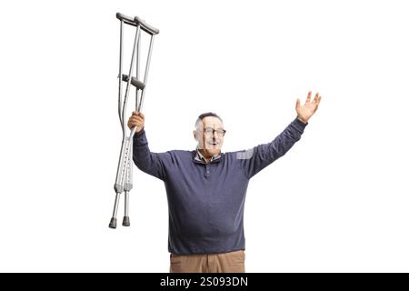 Happy mature man raising crutches and recovering from knee surgery ...