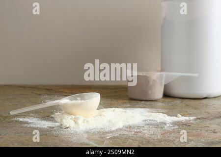 Protein powder and scoops on grey textured table Stock Photo - Alamy