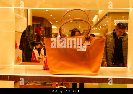 Bright yellow handbag displayed in a busy retail shop attracting ...