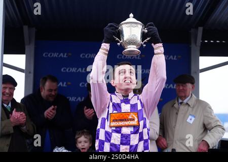 Jockey Charlie Hammond poses for a photo with the trophy after winning ...