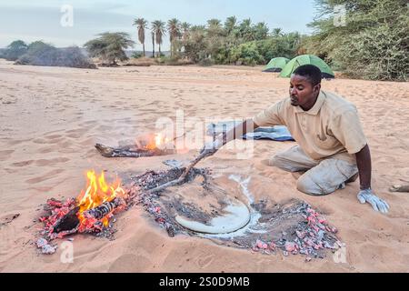 Mauritania, Azweiga, cook preparing traditional desert bread cooked ...