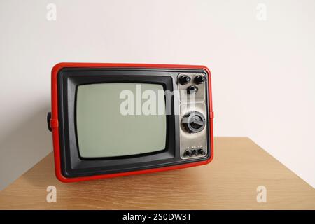Retro tv set on nightstand against white wall Stock Photo - Alamy