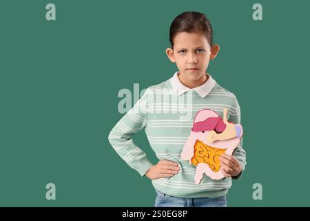 Teenage girl with appendicitis and paper digestive system on green ...