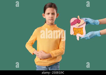 Teenage girl with appendicitis and paper digestive system on green ...
