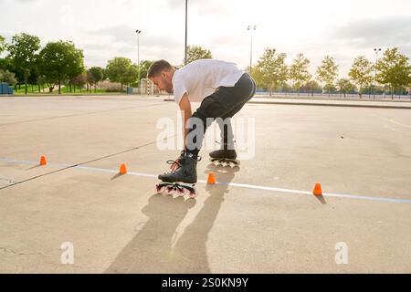 Man adjusting cones while rollerblading in an outdoor park Stock Photo ...