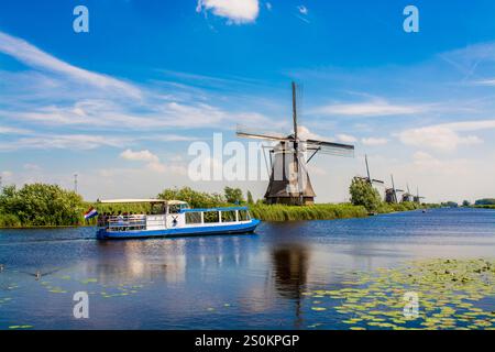 Canal tour boat and windmill in Unesco World Heritage Site, Kinderdijk ...
