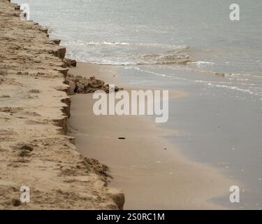 Sand eroding from the beach, crumbling and falling down into big clumps ...