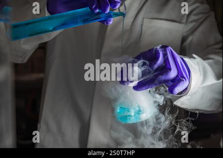 Smoky experiments with blue droplets. Scientist working on chemical ...