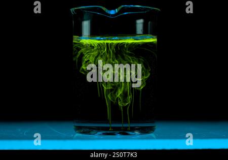 Dissolution and spread of a yellow substance in a flask with a clear ...