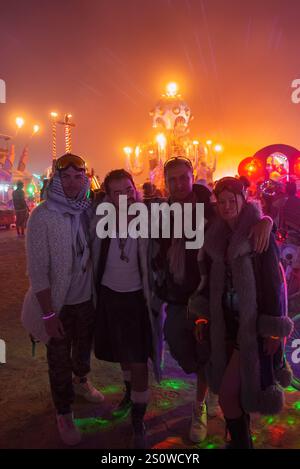 Four individuals in fur lined outfits stand together, smiling amidst ...