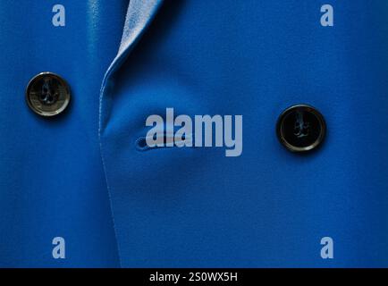 A row of buttons on the sleeve of a blue men's suit. clothing element ...