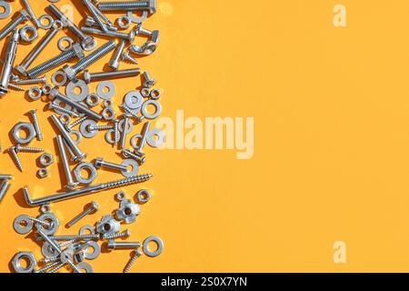 Different tap bolts, screws and chrome nuts on orange background Stock ...