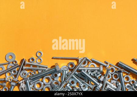 Different tap bolts, screws and chrome nuts on orange background Stock ...