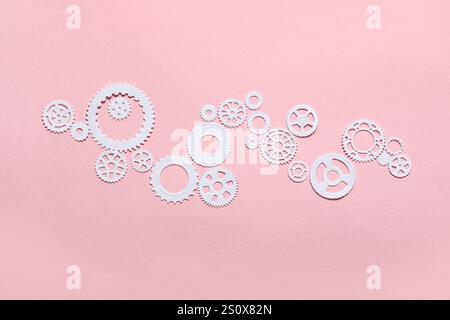 White paper gears on pink background Stock Photo - Alamy