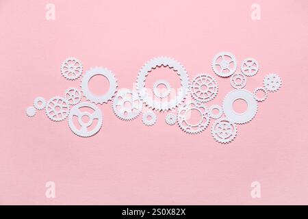 White paper gears on pink background Stock Photo - Alamy