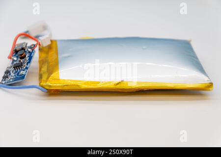 Bloated lithium-ion battery with USB connector on white background ...