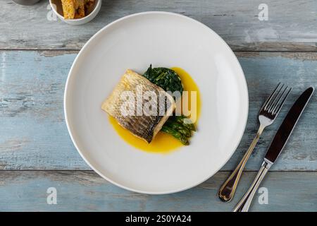 Grilled sea bass fillet served with garnishes in a fine dining ...