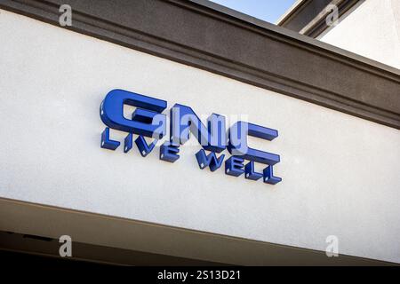 GNC Live Well sign on exterior of commercial building with blue tile ...