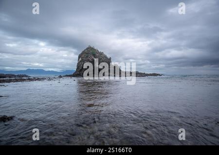 A dramatic coastal scene of Diguisit, Aurora featuring two rugged rock ...