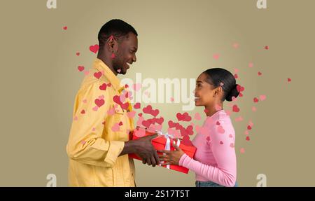 Sincere gifts. Beautiful couple in love on red studio background. Saint ...