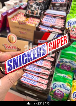 Hand holds Chocolate bar Snickers, isolated on a transparent background ...