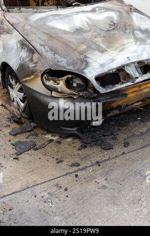 Burnt passenger car standing on the road. Vehicle with interior largely ...