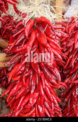 Sun dried red chili peppers on wooden surface with mortar and pestle ...