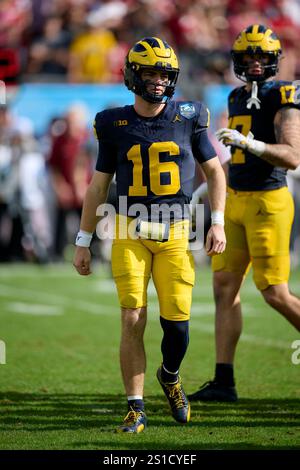 Michigan quarterback Davis Warren (16) gets tackled by Jihaad Campbell ...