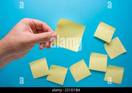 hand hold adhesive notes on glass wall at workplace. Sticky note paper ...