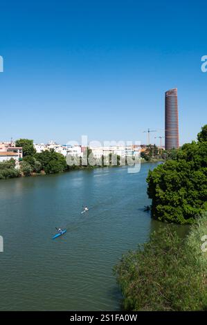 Guadalquiver river in summer view from the bridge, Sevilla Tower in the ...