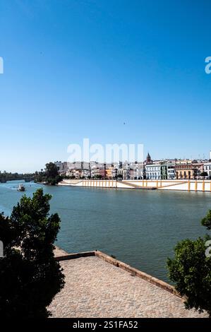 Guadalquiver river in summer view from the bridge, Sevilla Tower in the ...