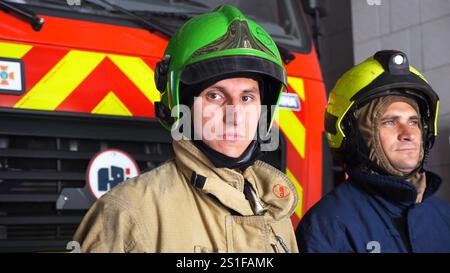 Portrait of confident firefighters at fire station against clear sky ...