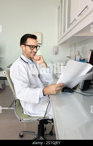 happy male doctor reading medical report in folder Stock Photo - Alamy