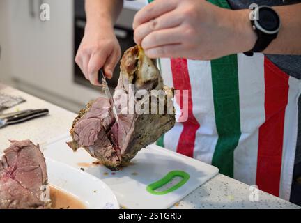Chef cooking a delicious leg of lamb on a barbecue with colors peppers ...