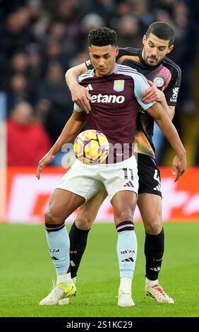 Aston Villa's Ollie Watkins, front, defends the ball from Brentford's ...