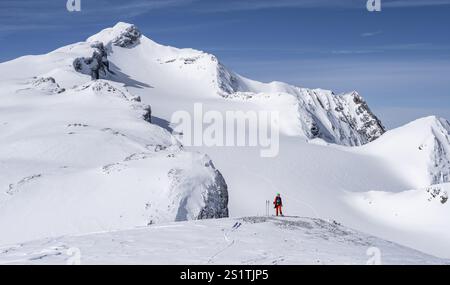 Ski tourers in front of snow-covered mountain peaks, mountain panorama ...