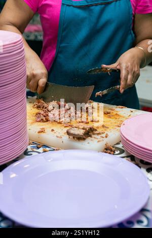 Unrecognizable woman serving meat on a plate during a Mexican party ...