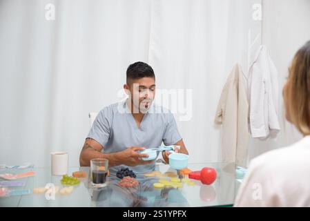 A nutritionist explains portion control to a patient using cup ...