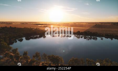 Aesthetic sunset over the peaceful countryside with cypress trees along ...