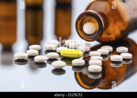 Many tablets with a glass container. Symbolic photo for addiction and ...