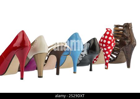 Different coloured shoes with high heels in front of a white background ...