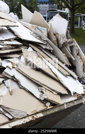 Plasterboard sheets are stored in a waste container for disposal ...