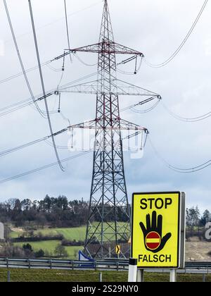 A pylon of a power line and a stop sign. Symbolic photo for phasing out ...