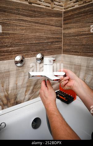 professional plumber working in a bathroom, plumbing repair service ...