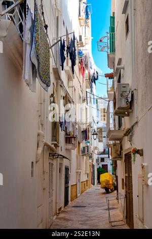 Narrow historic street lined with colorful pastel houses and blue ...