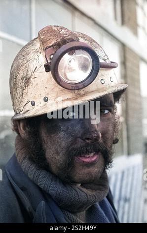 Young coal miner with his face covered in coal dust after working a ...