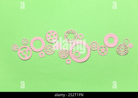 Green paper gears on pink background Stock Photo - Alamy