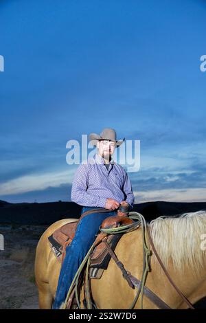 A rider sits confidently atop a horse in front of a quaint house ...